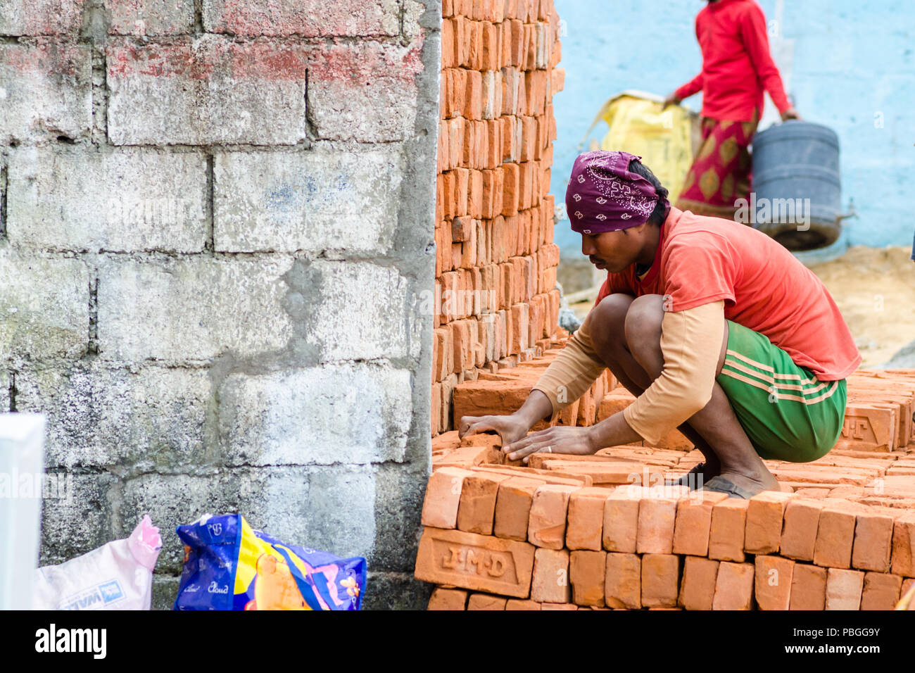 Worker piling up bricks in Pokhara, Nepal Stock Photo - Alamy