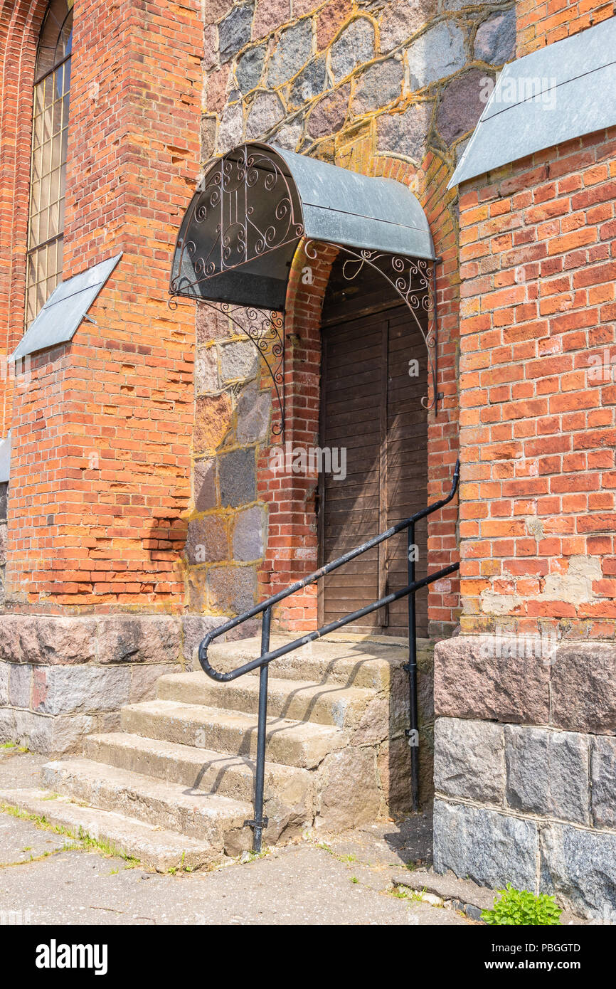 Ancient wooden gate with an arch in the wall made of brick and stone ...