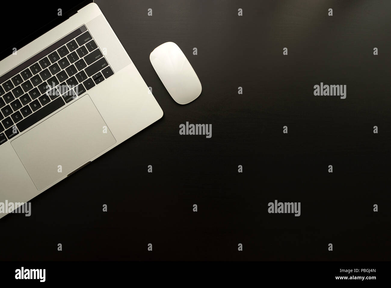 laptop and mouse over black wooden table monochromatic flat lay ...