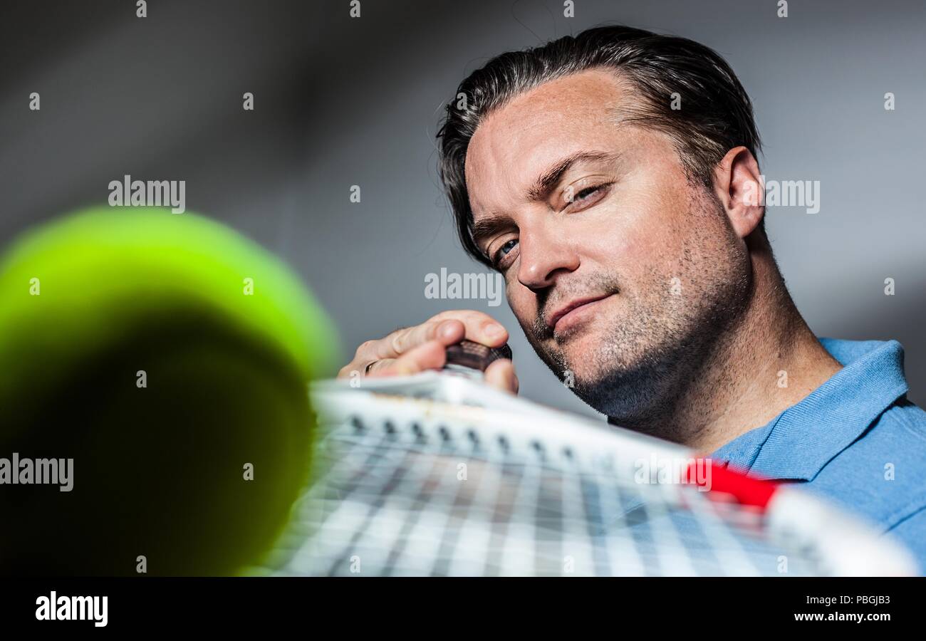 portrait of a handsome man with a tennis racket Stock Photo - Alamy
