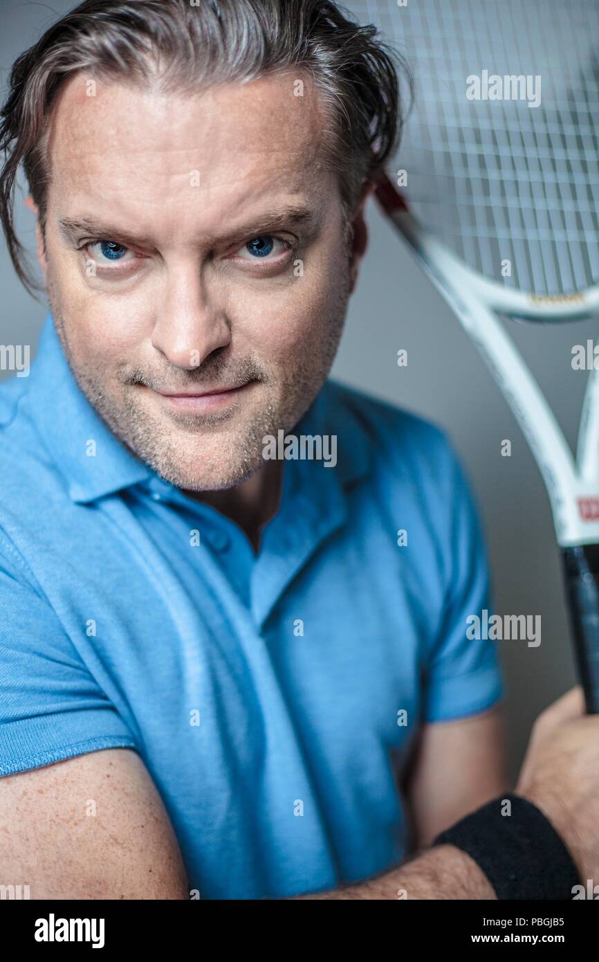 portrait of a handsome man with a tennis racket Stock Photo - Alamy