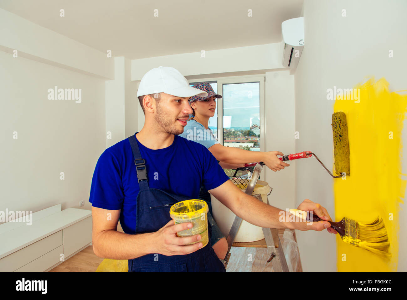 Sweet couple renovate their room with yellow color Stock Photo - Alamy