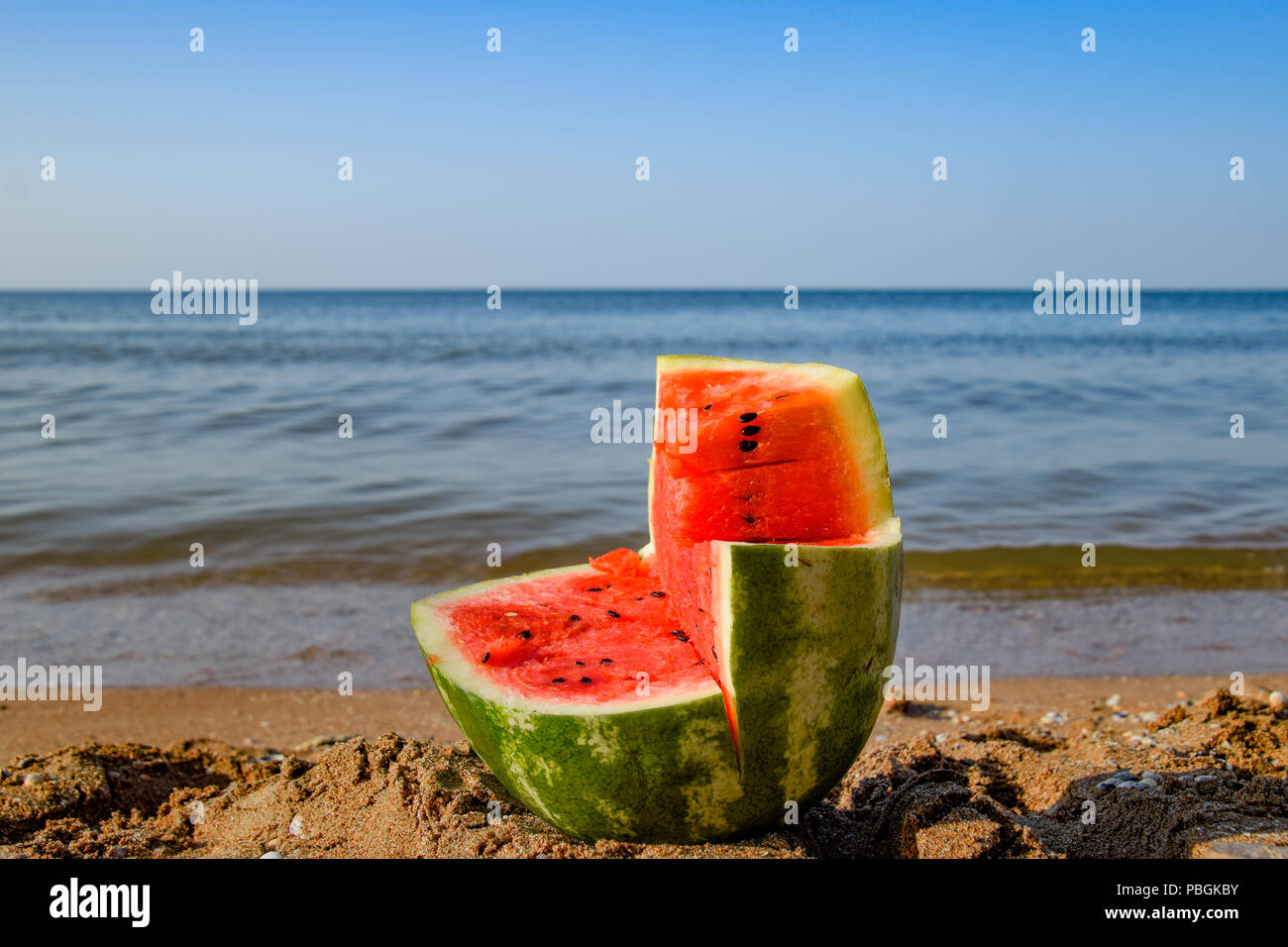 The cut watermelon lies on the seashore. Watermelon in the sea Stock ...