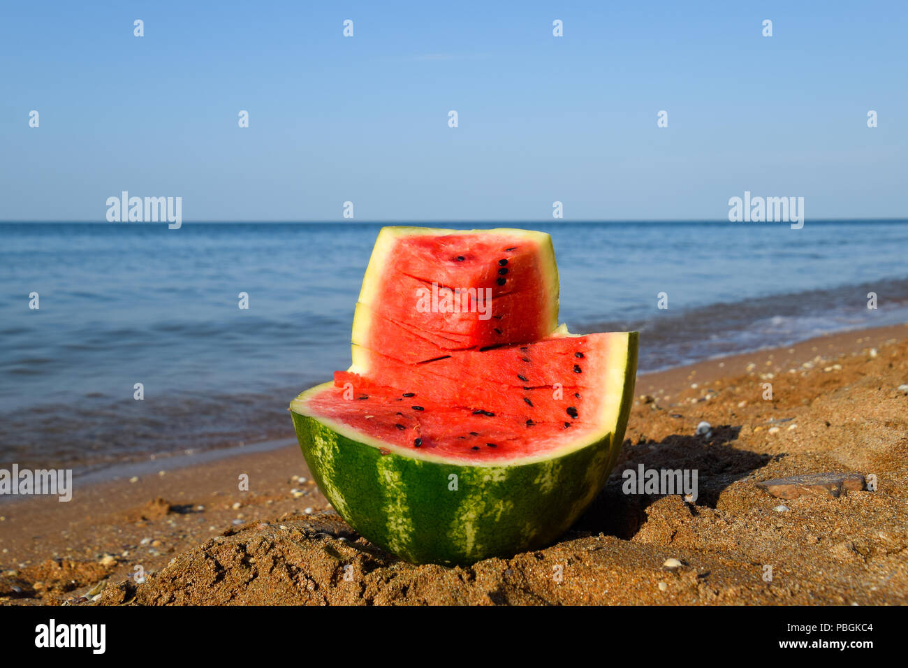 The cut watermelon lies on the seashore. Watermelon in the sea Stock ...