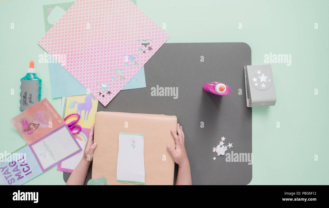 Decorating present for kids birthday with craft paper Stock Photo - Alamy