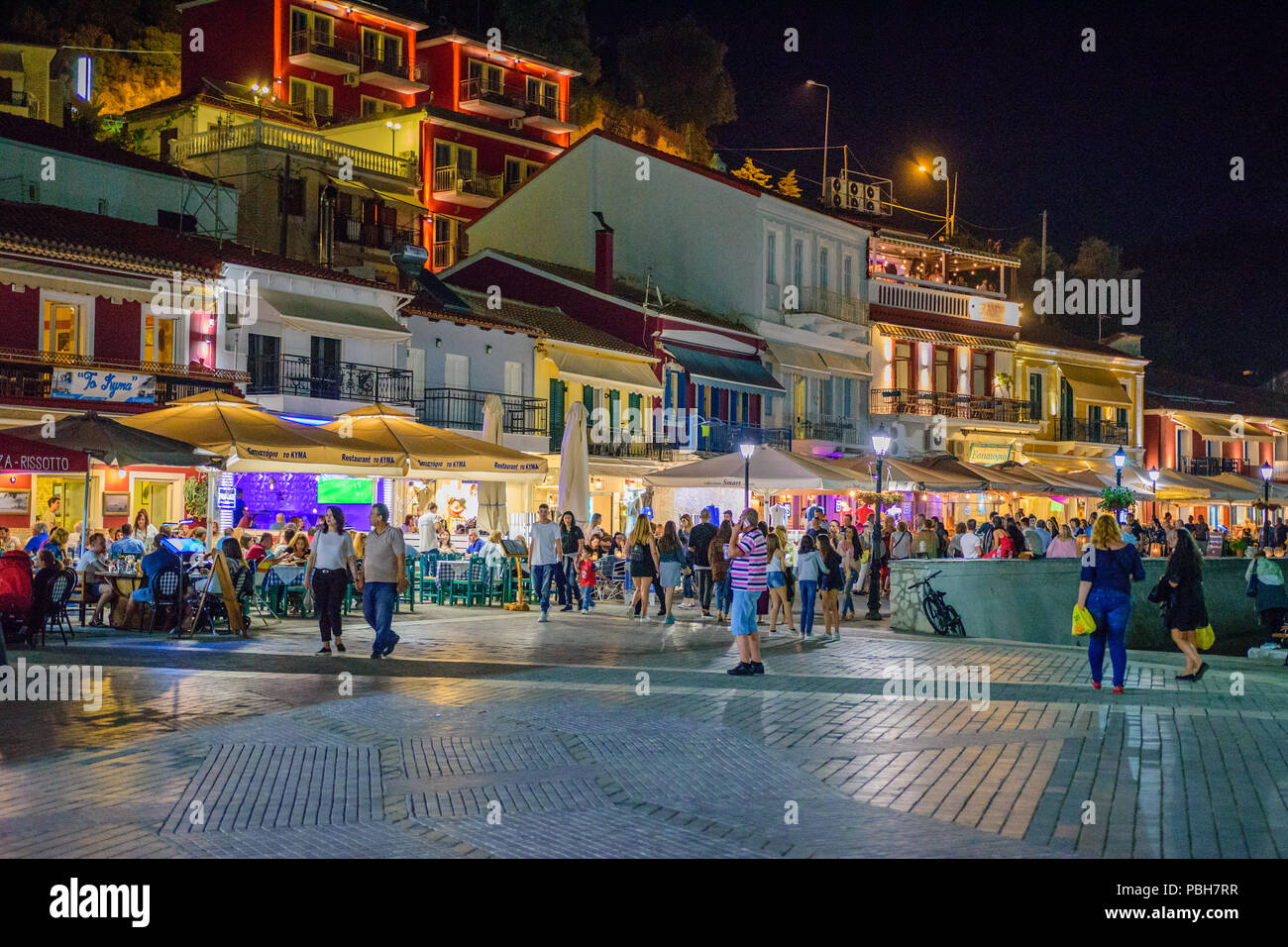 The amazing coastal city of Parga at night. Tourists and visitors walk ...