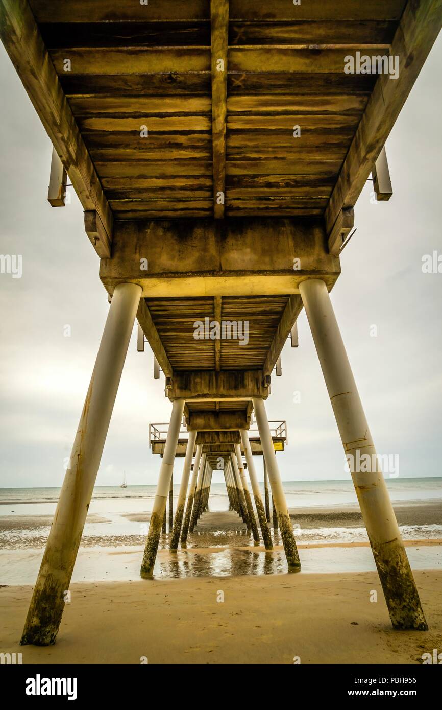 Symmetric view from below a pier over the ocean in Australia Stock ...