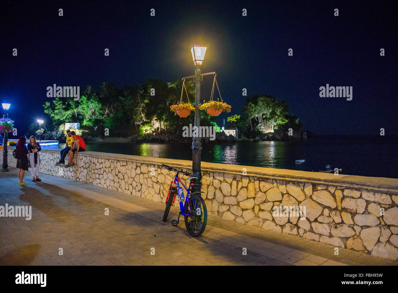 The amazing coastal city of Parga at night. Tourists and visitors walk ...
