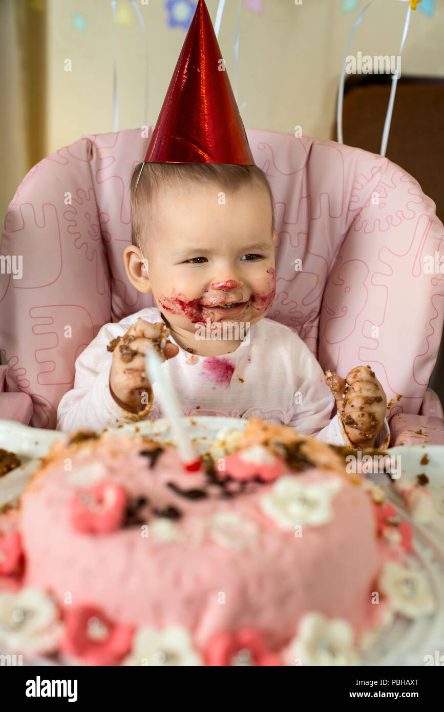 one-year-old little girl solemnize birthday, eating cake, vertical ...