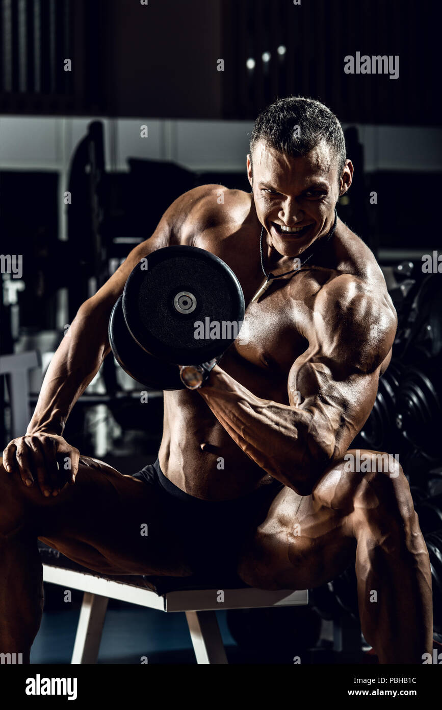 very power guy - bodybuilder, execute exercise with weight, inside gym ...