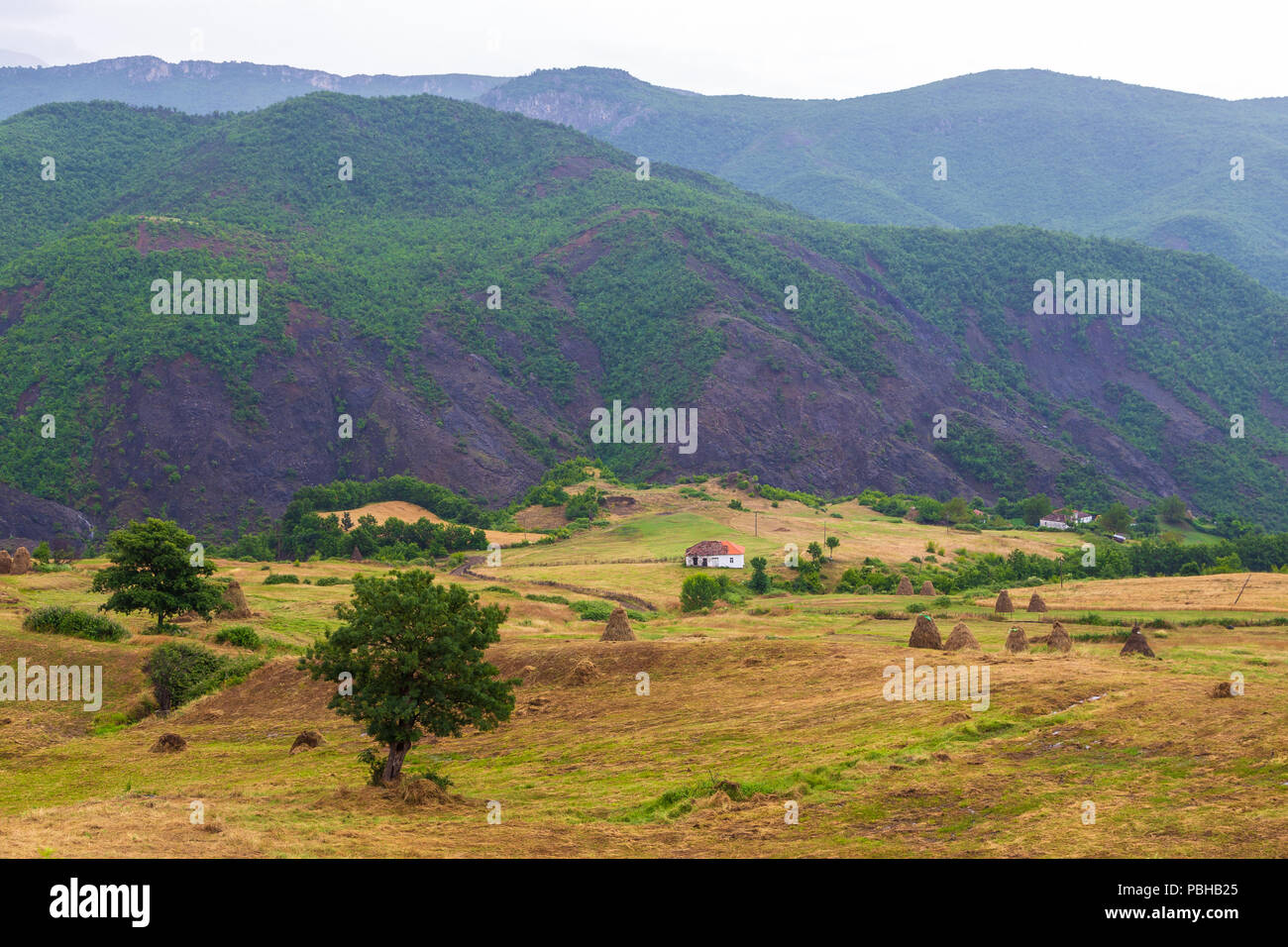 Scenic landscape view in Albanian mountain with small village and hay ...