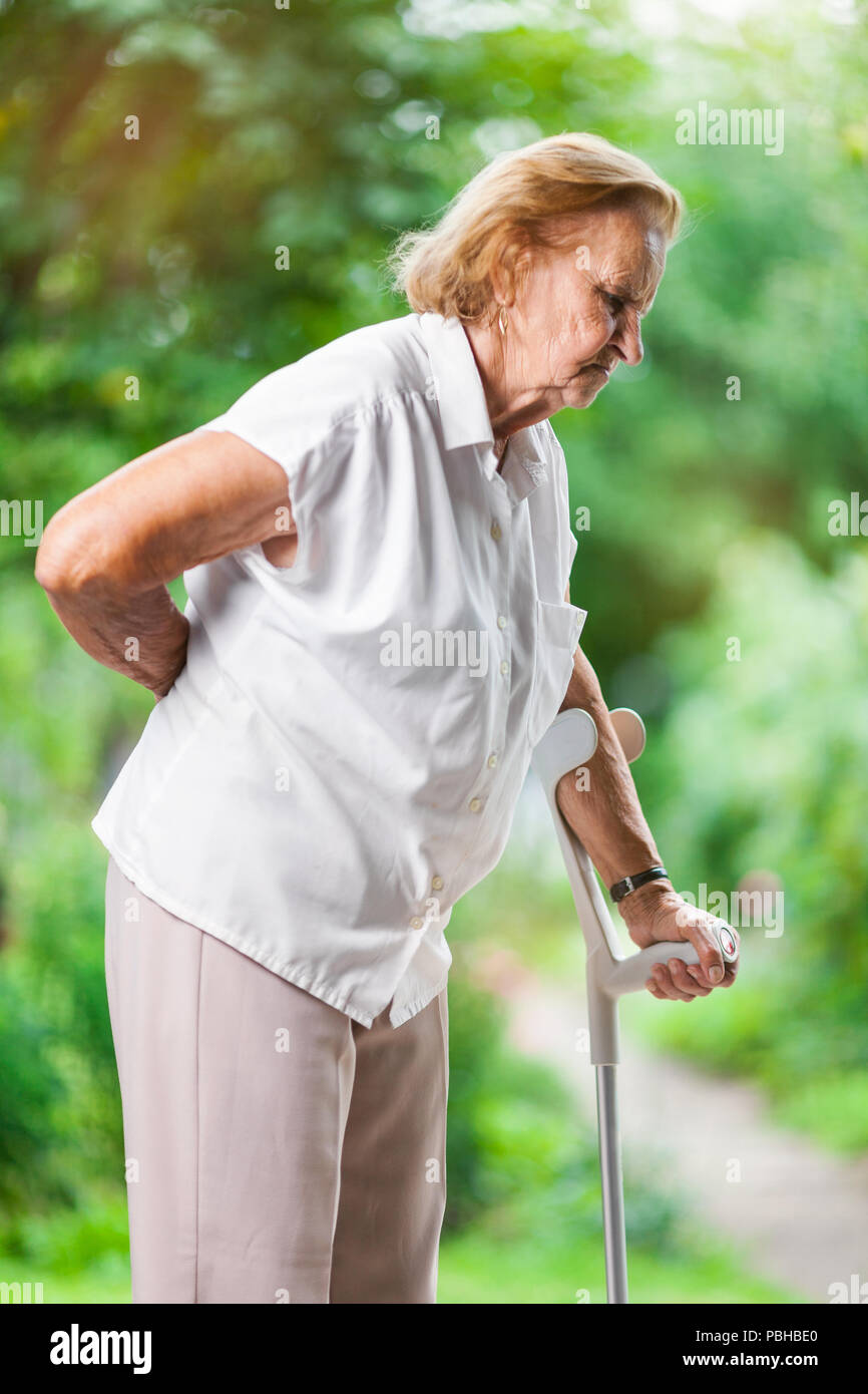 Elderly woman outdoors with lower back pain Stock Photo - Alamy
