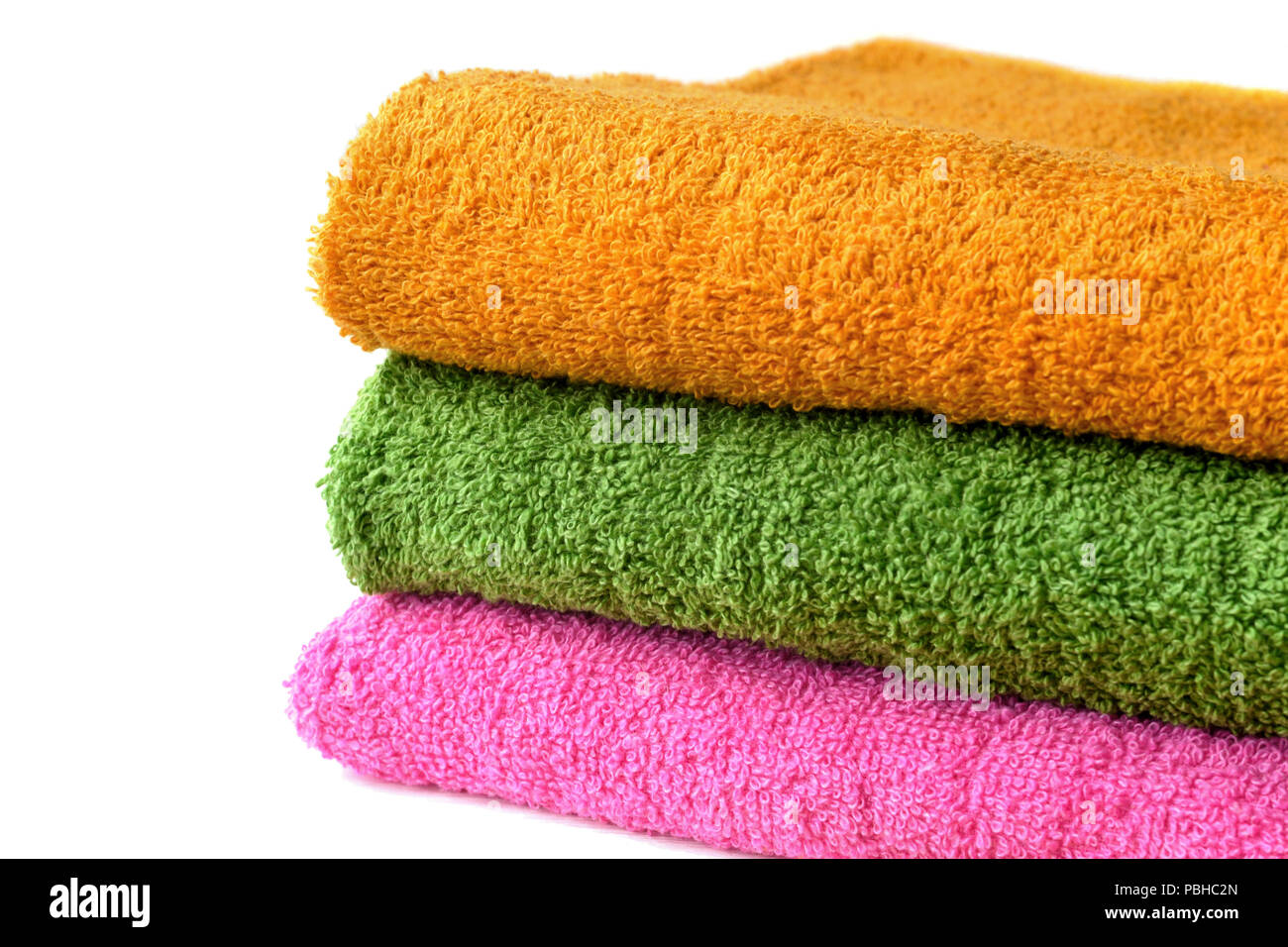 Colored towels in a pile on a white background Stock Photo - Alamy