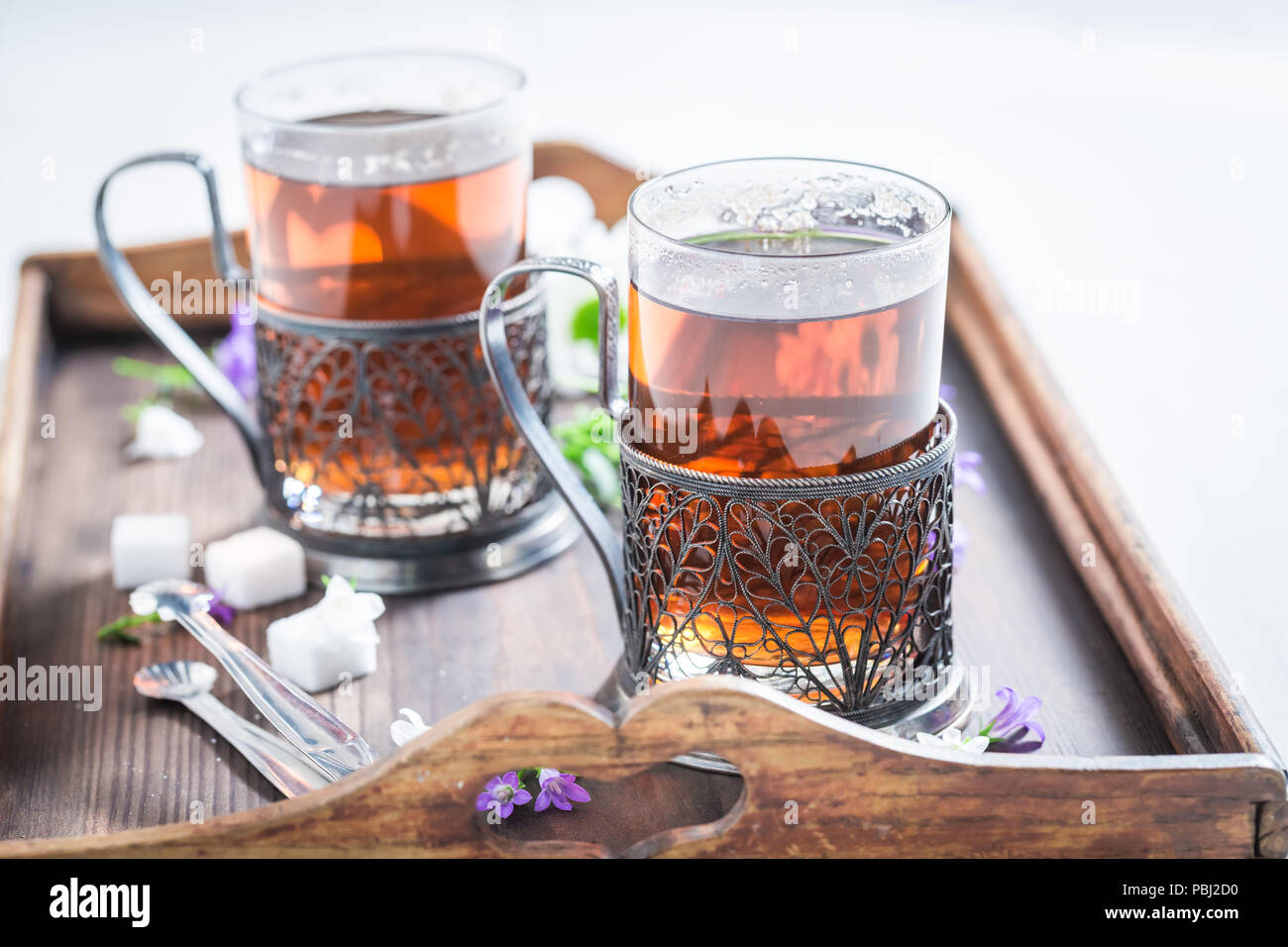 Tasty hot tea with fresh green leaves on white background Stock Photo ...