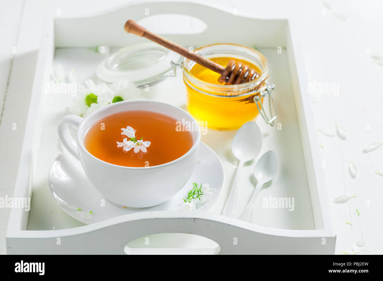 Ttea with honey with spring flowers on white background Stock Photo - Alamy