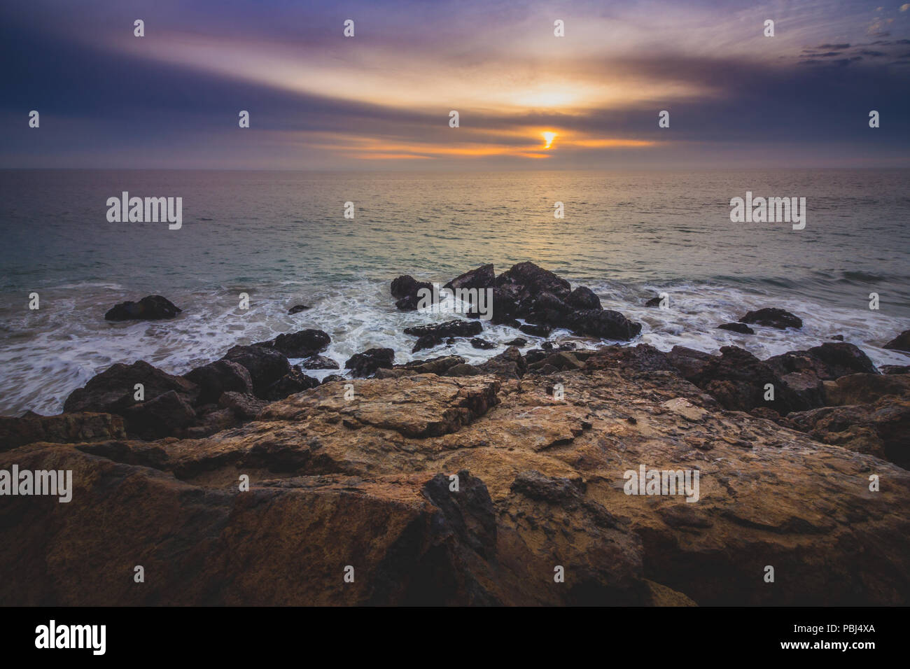 Dramatic sky at sunset along Point Dume State Beach with waves crashing ...