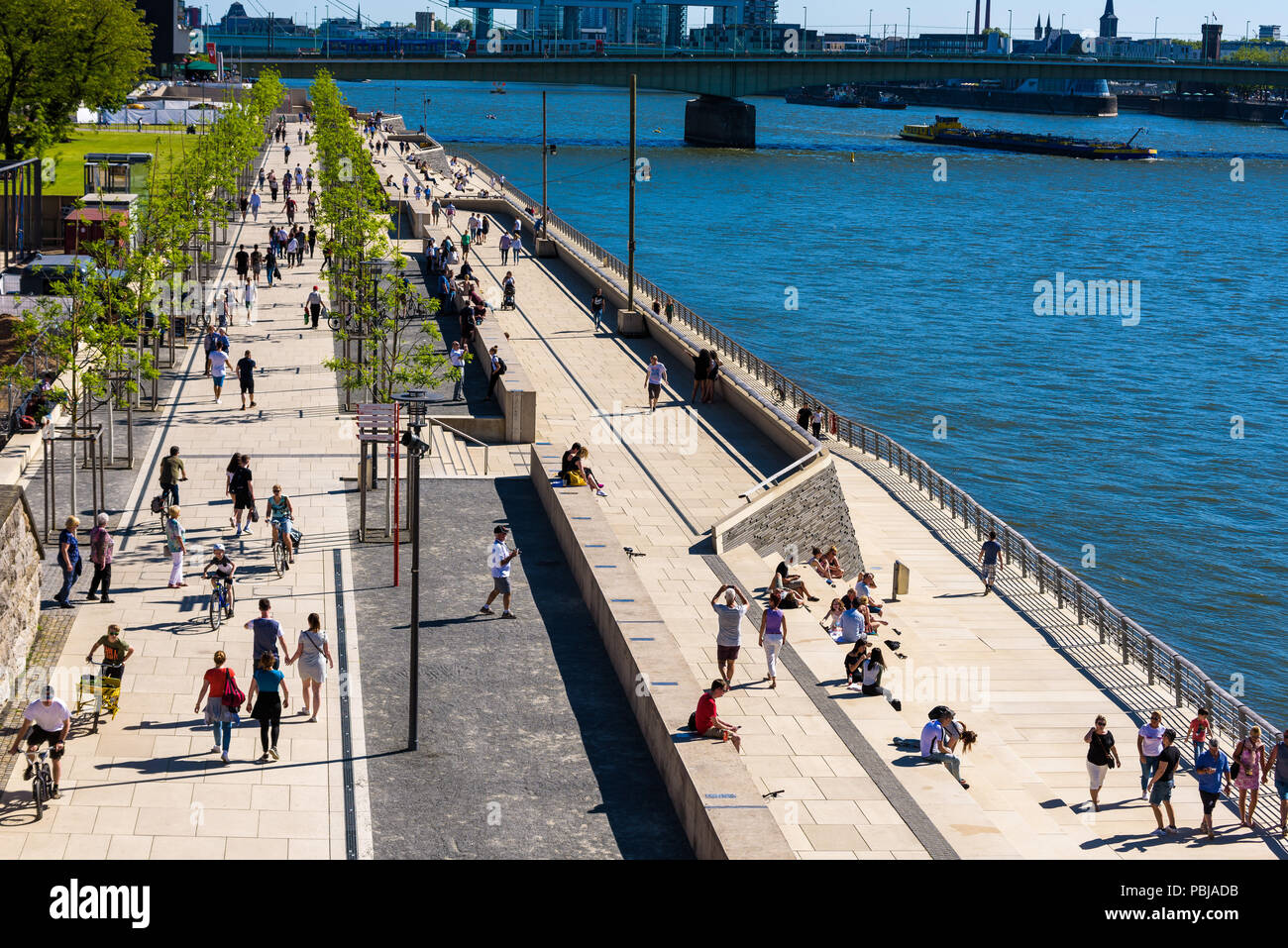 Cologne, Germany - Local and tourists walking and cycling on the Rhine ...