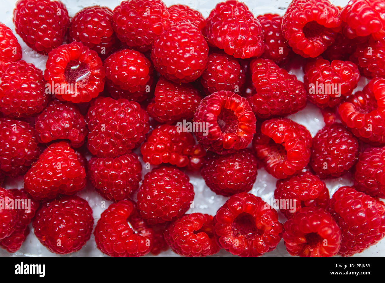 Red bright raspberry with waterdrops flat view Stock Photo - Alamy