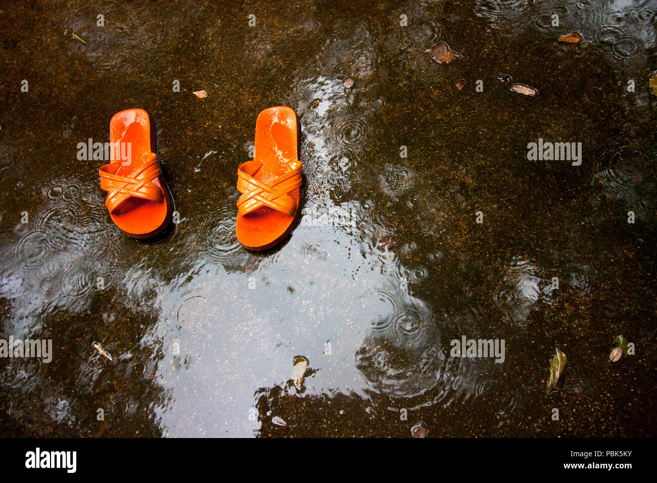 Orange flip-flop in rain season Stock Photo - Alamy