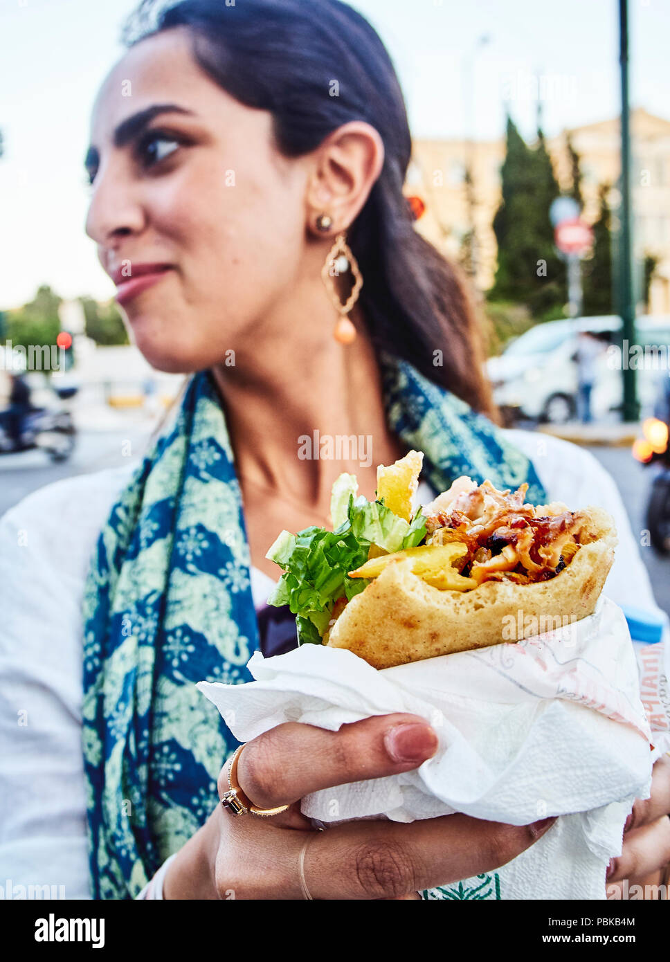 Athens, Greece - June 29, 2018. Greek woman eating a traditional Gyros ...