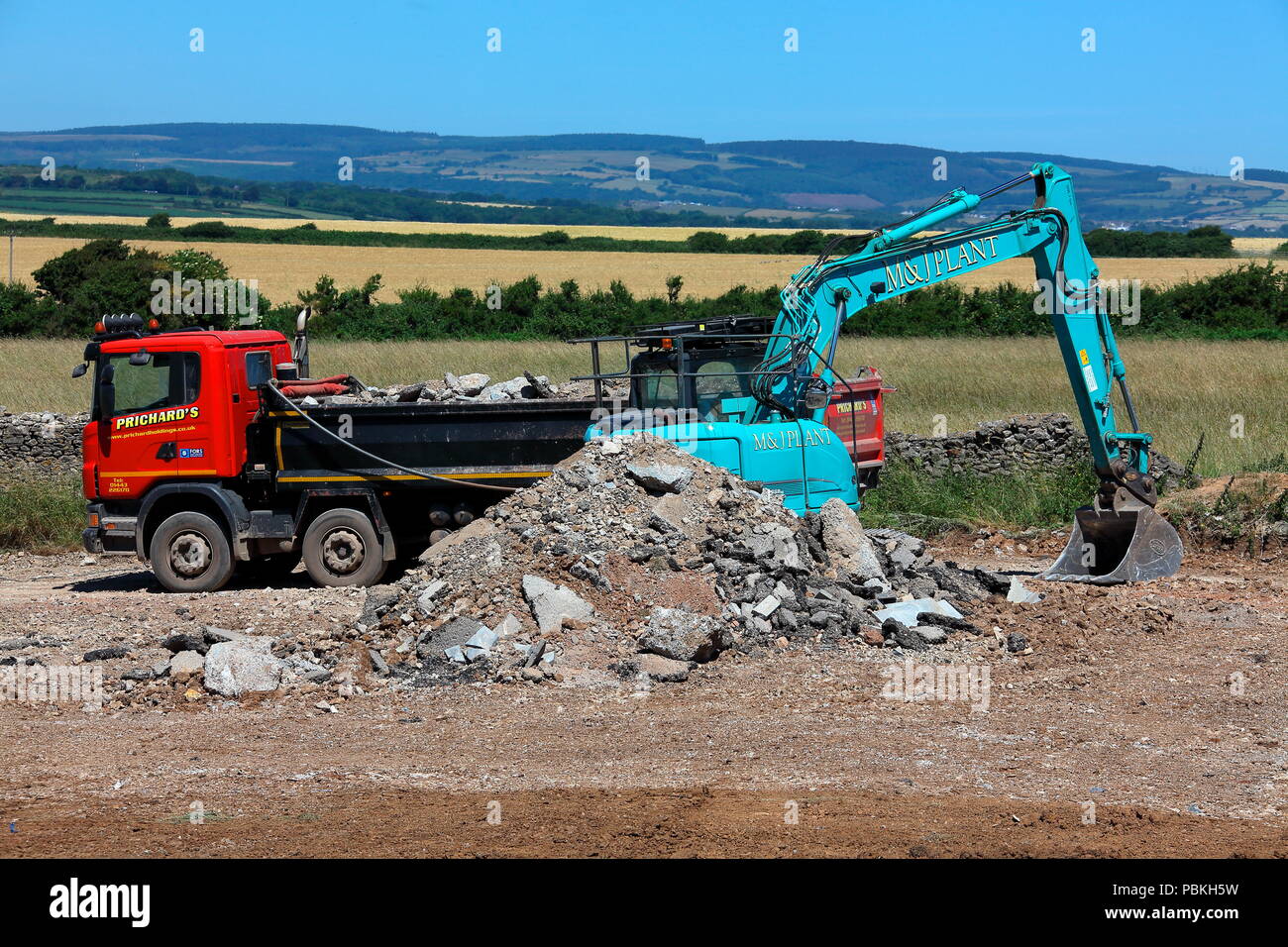 Huge tracked digger adding a load to a large lorry during restoration ...