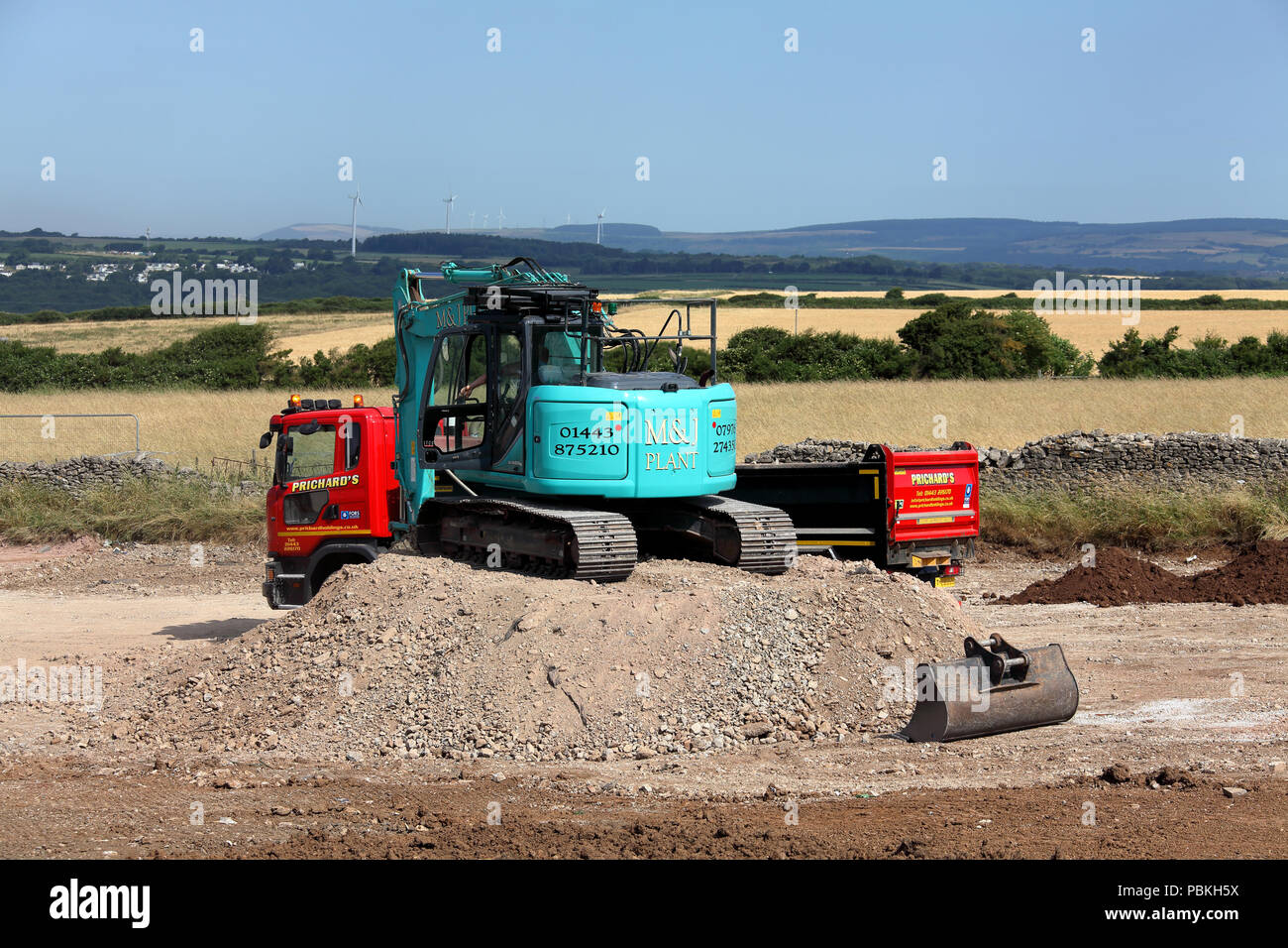 Loading up a lorry one ton at a time with a large digger filling up the ...