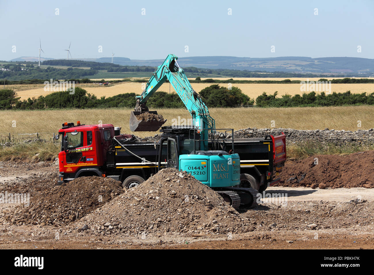 Huge tracked digger adding a load to a large lorry during restoration ...