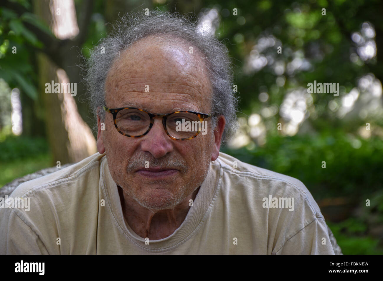 Smiling older man sitting outside Stock Photo - Alamy