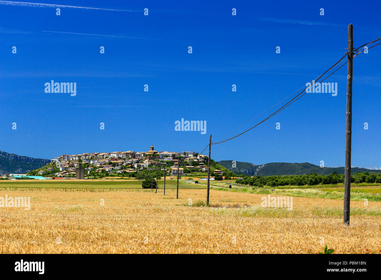 Road leading to distant Spanish hilltop town of Berdun in northern ...