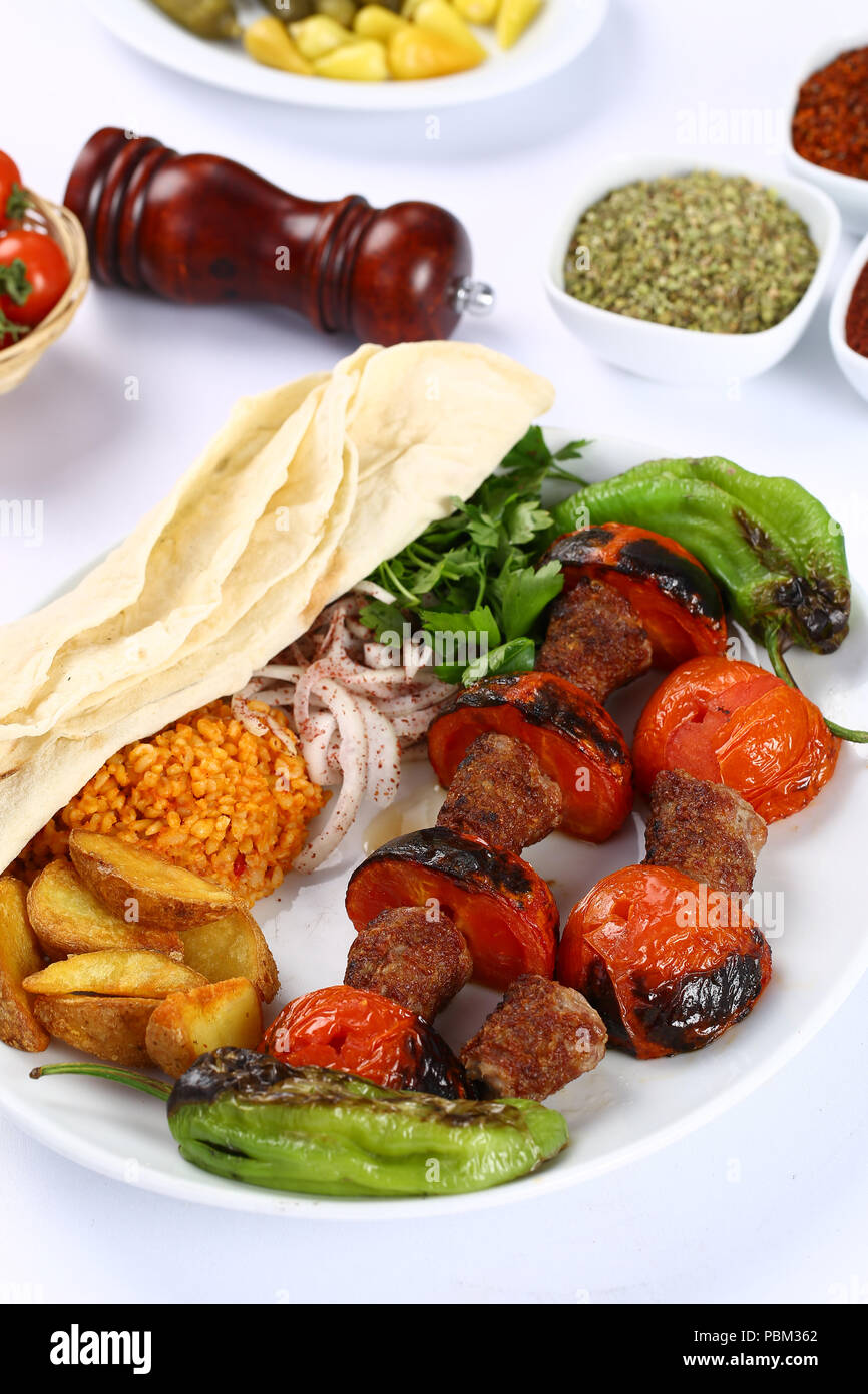 Skewers of meat kebab with fried tomato and bulgur pilau Stock Photo ...