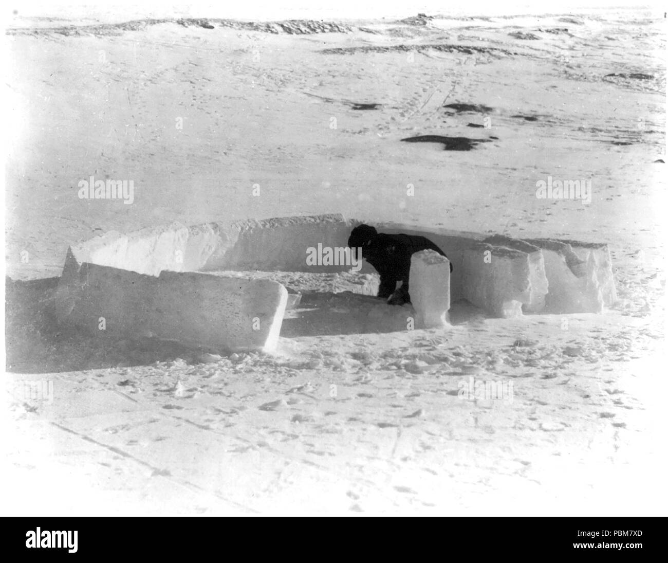 Eskimo building an igloo; completing the first layer of ice blocks 1920 ...