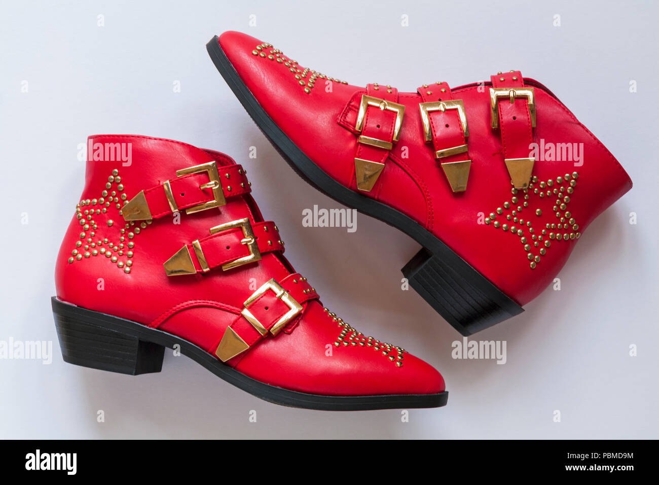 red ankle boots with studs arranged in shape of star and buckles ...