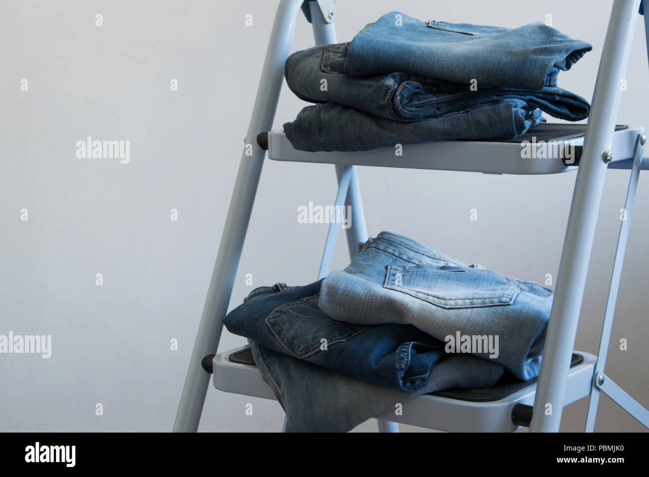 Several pairs of jeans on a ladder, fasion-industry concept Stock Photo ...