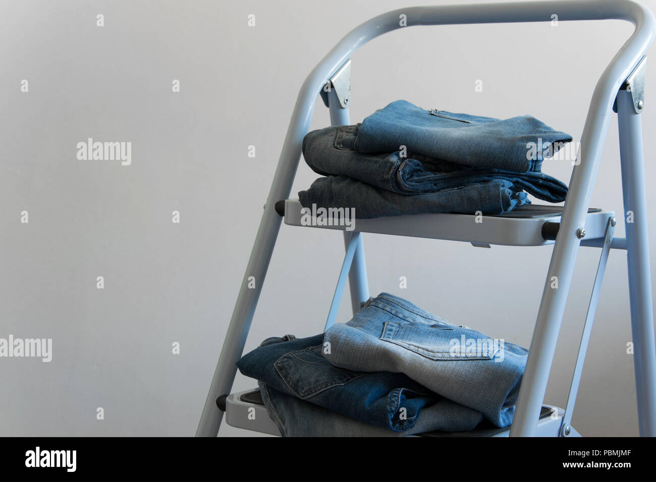 Several pairs of jeans on a ladder, fasion-industry concept Stock Photo ...