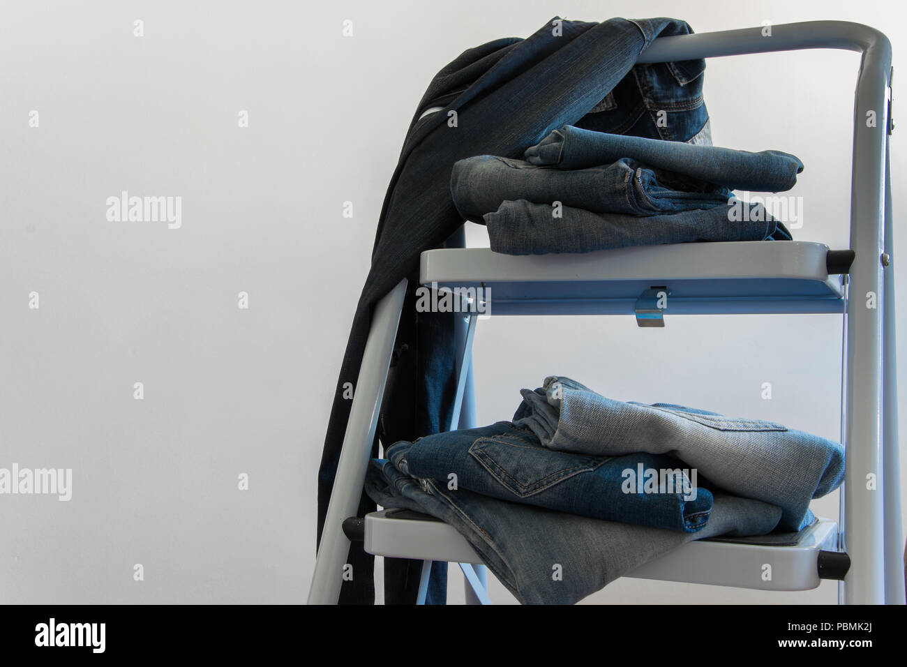 Several pairs of jeans on a ladder, fasion-industry concept Stock Photo ...