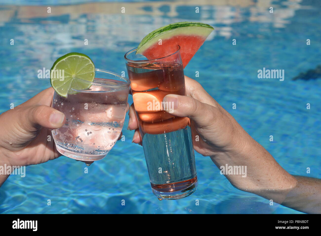 Cheers! Enjoying a refreshing cocktail in the swimming pool Stock Photo ...
