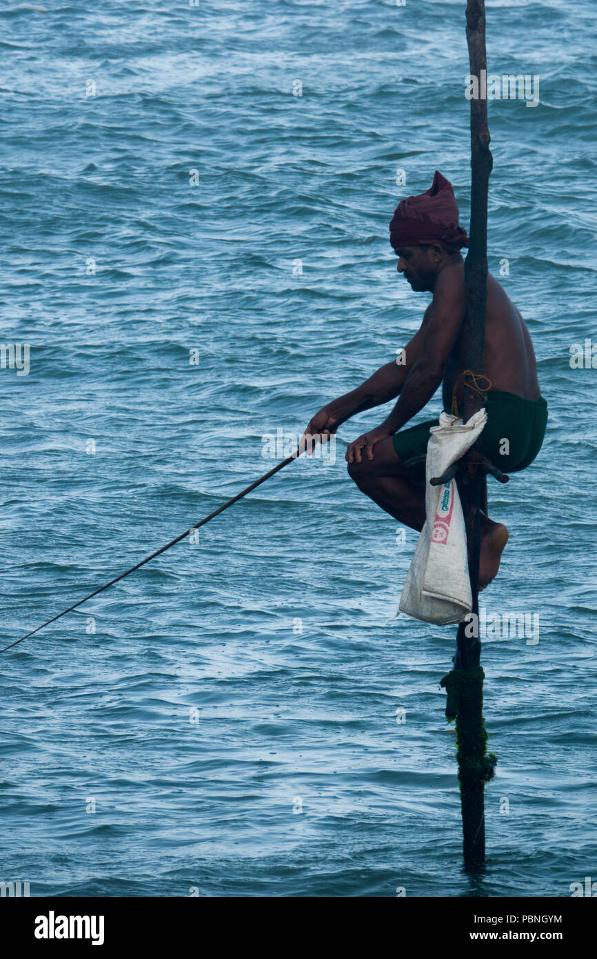 Sri Lankan stilt fishermen early morning fishing at Ahangama beach ...