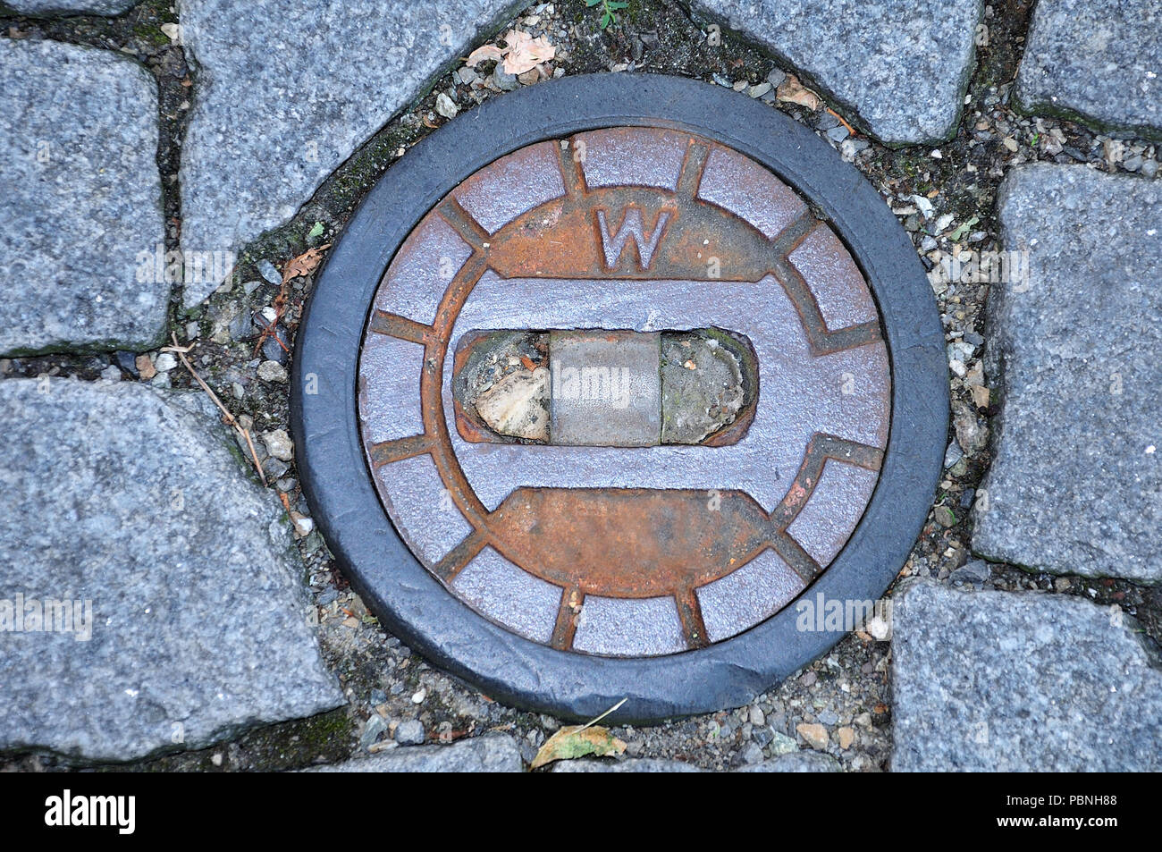 maintenance lid of water conduit in pavement on a city street Stock ...