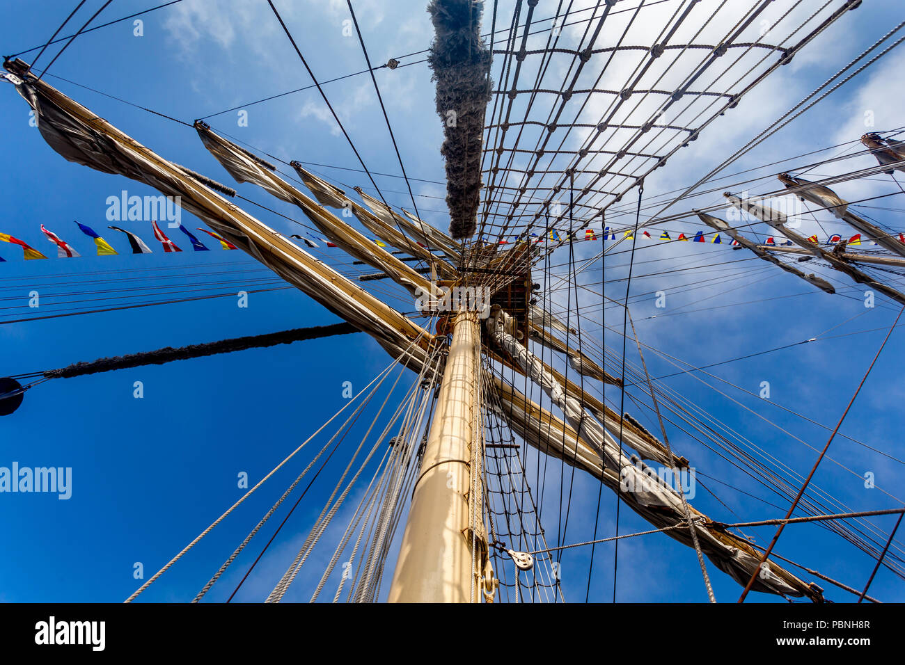 Cable ladders, mast and ropes of sailing ship against the blue sky ...