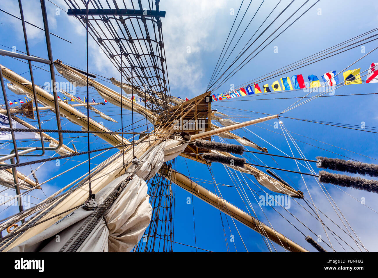 Cable ladders, mast and ropes of sailing ship against the blue sky ...