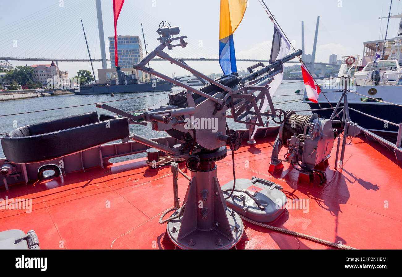 Machine gun on modern military battleship. View on Zolotoy bridge over ...