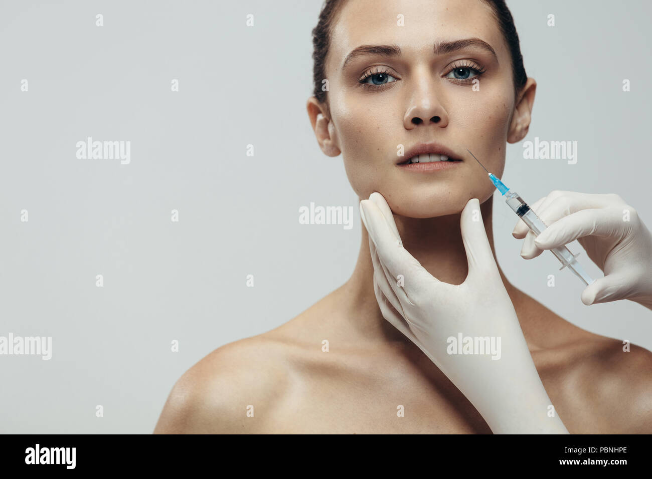 Portrait of young woman getting cosmetic injection. Close up of ...
