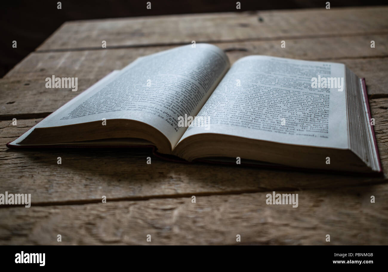 Old open book, on wooden table with a natural light Stock Photo - Alamy