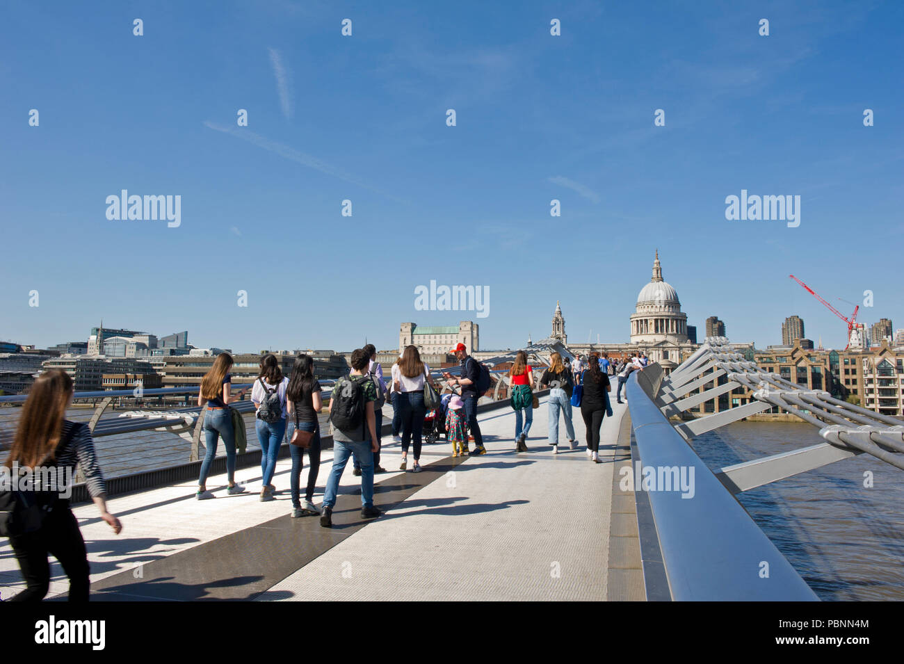 People crossing the Millennium bridge, London, England, UK Stock Photo ...