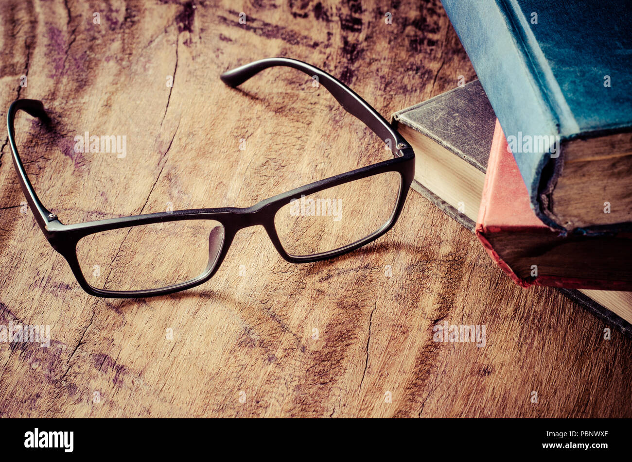 Glasses placed on a wooden table with books Stock Photo - Alamy