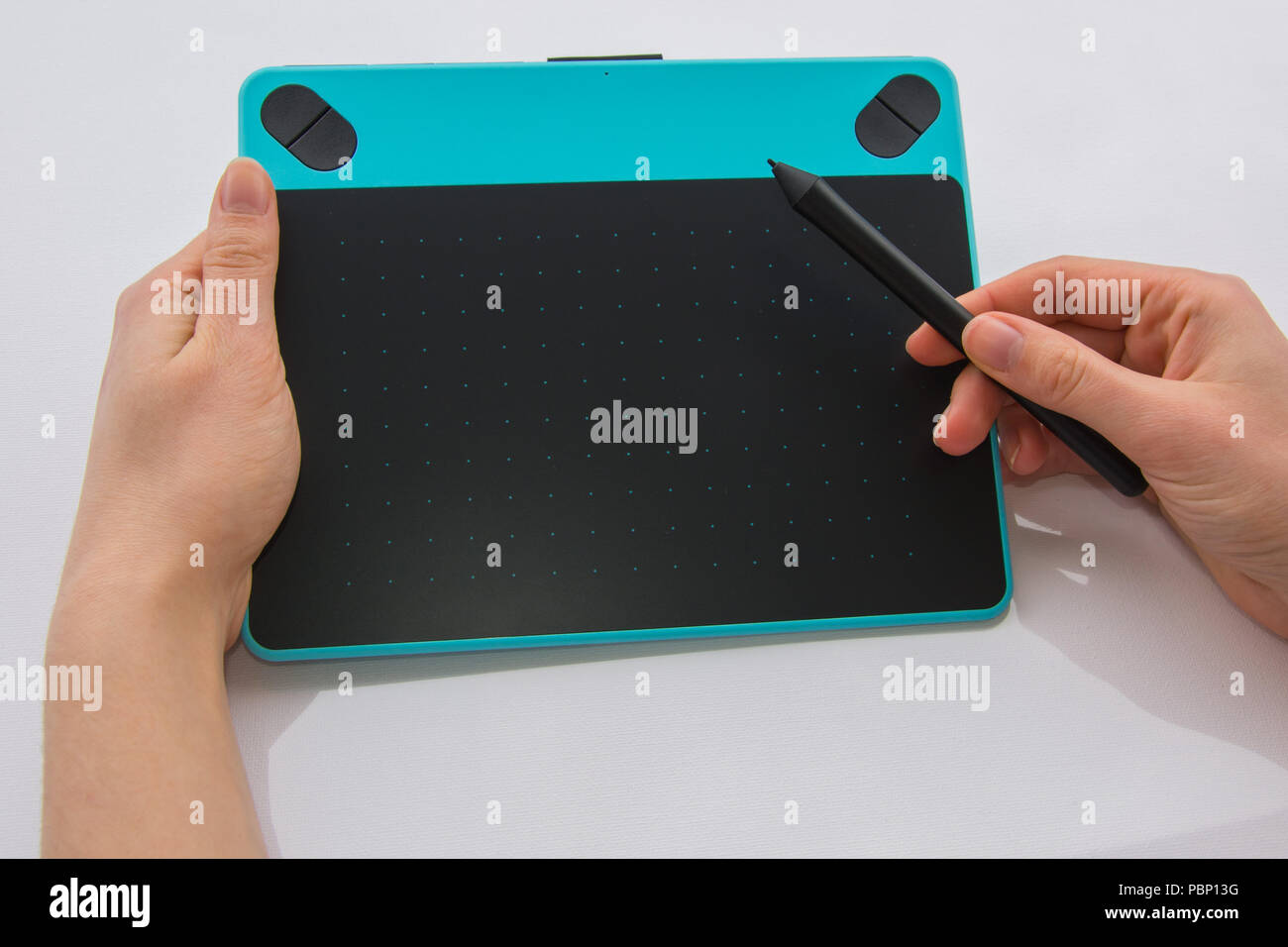 Graphic blue tablet in female hands in action Stock Photo - Alamy