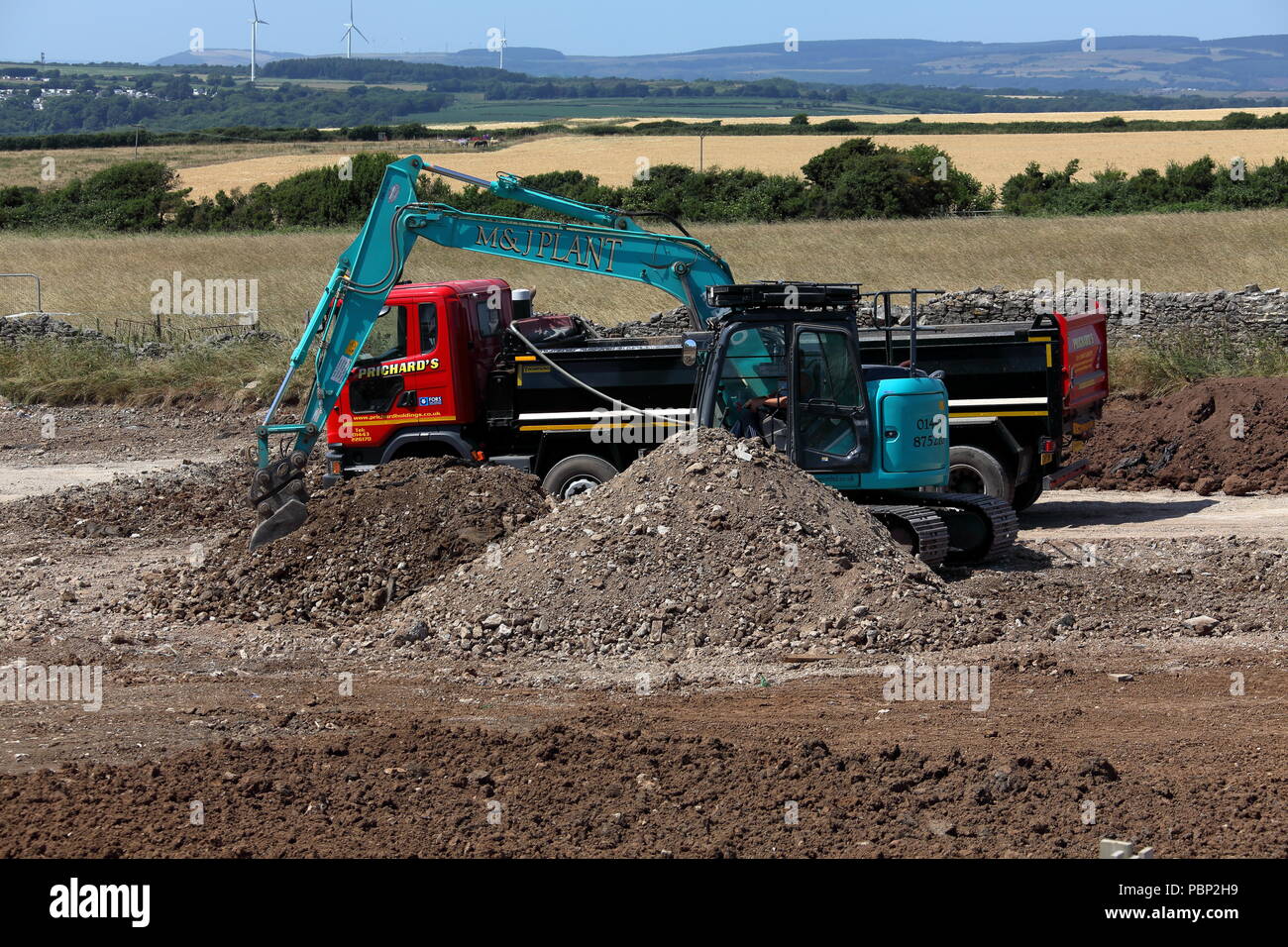Huge tracked digger adding a load to a large lorry during restoration ...
