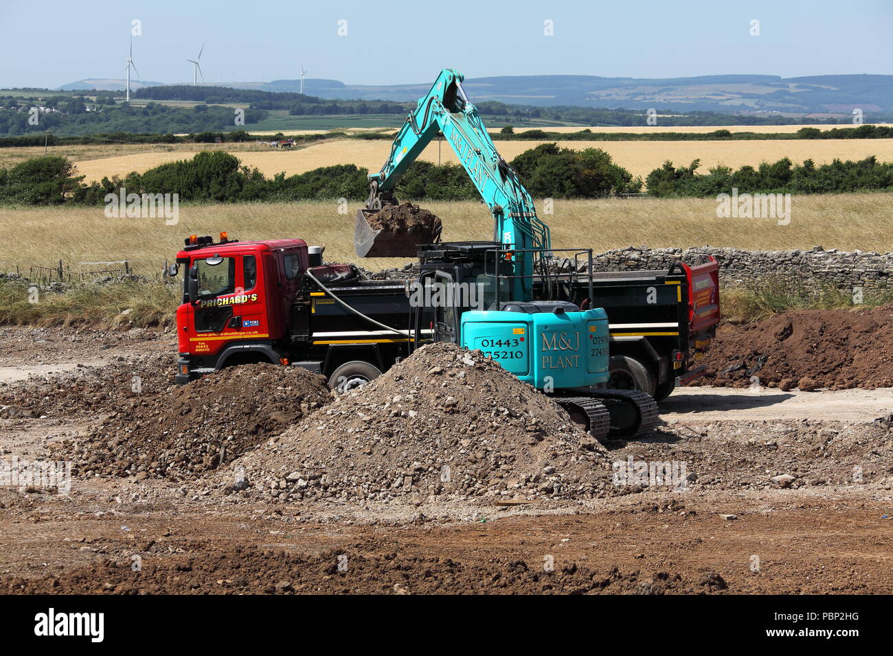 Huge tracked digger adding a load to a large lorry during restoration ...