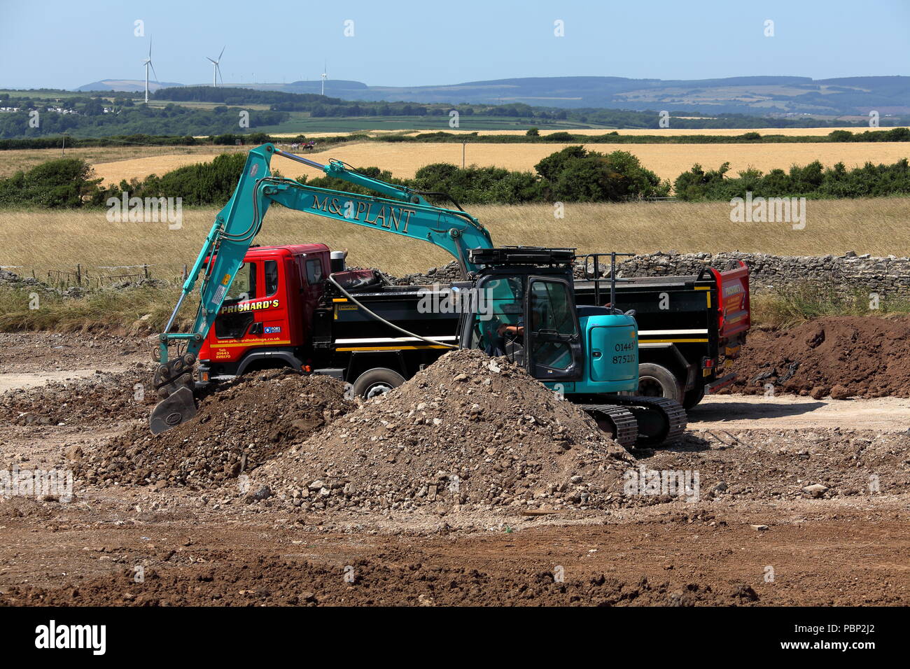 Huge tracked digger adding a load to a large lorry during restoration ...