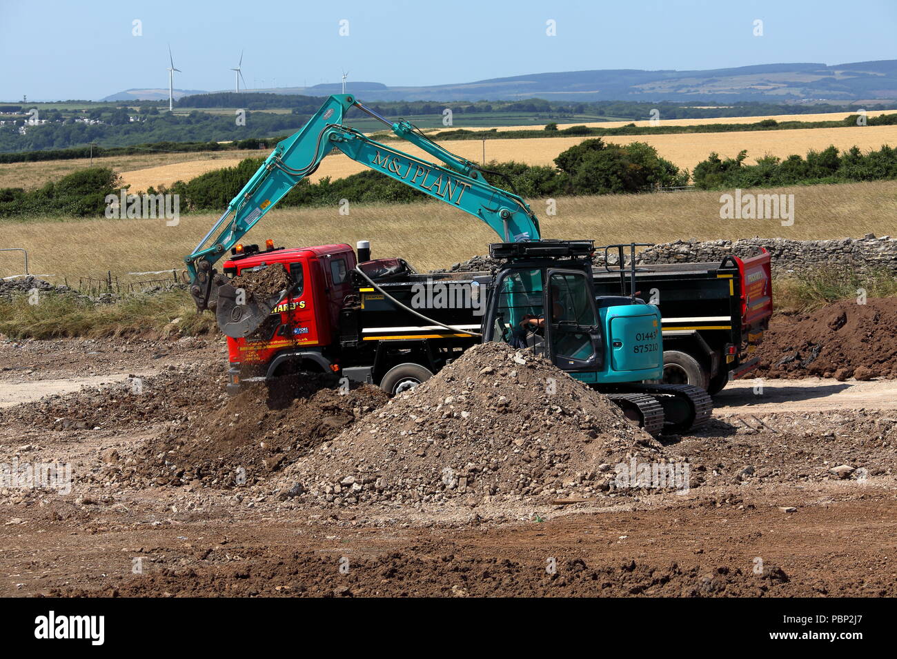 Huge tracked digger adding a load to a large lorry during restoration ...